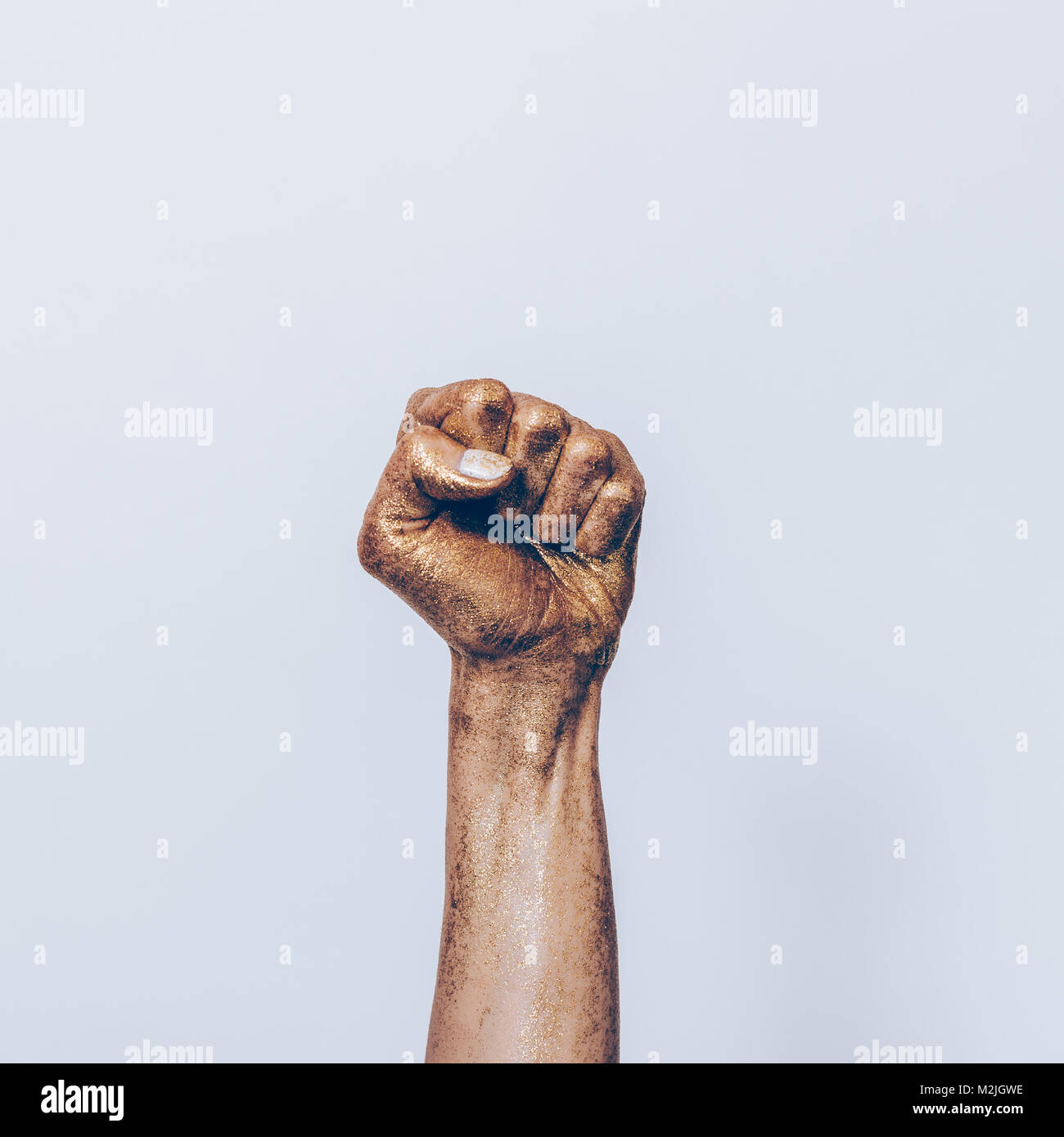 Female fist of golden color on a gray background close-up Stock Photo ...