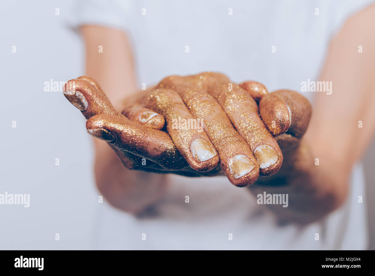 Golden female hands on a white background closeup Stock Photo - Alamy