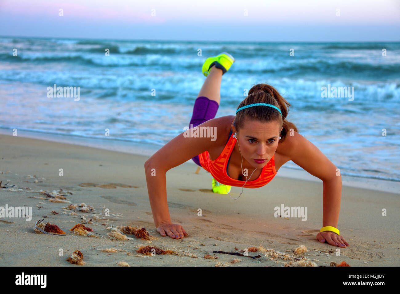 Refreshing wild sea side workout. fit woman in sport clothes on the ...