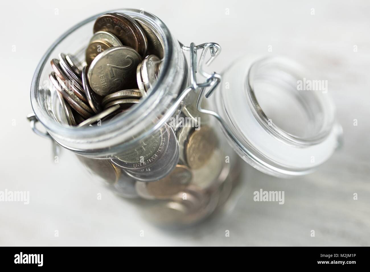 Coins in a glass jar Stock Photo - Alamy