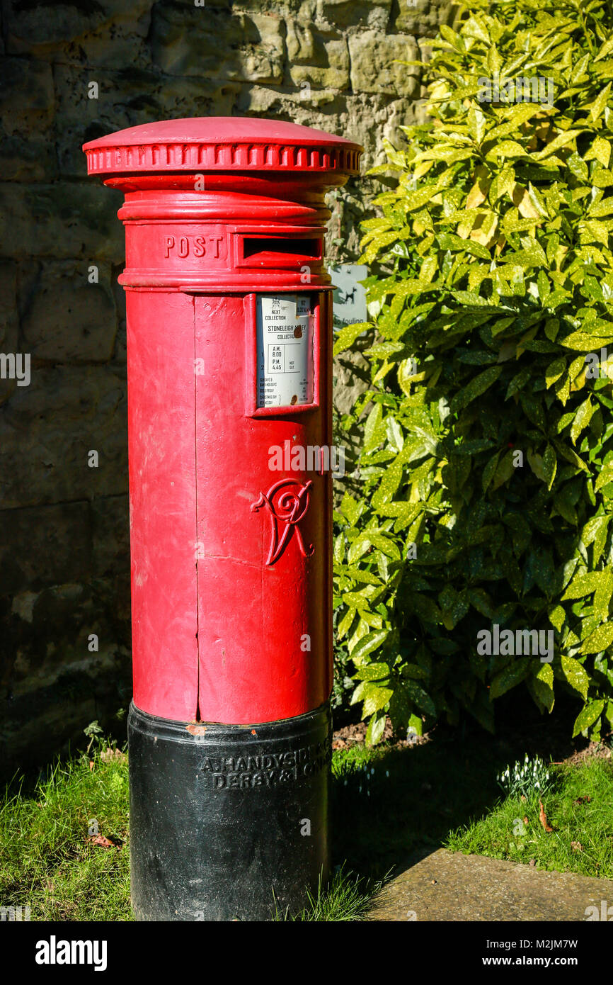 A red pillar,or post, box marked with the crest of Queen Victoria Stock ...