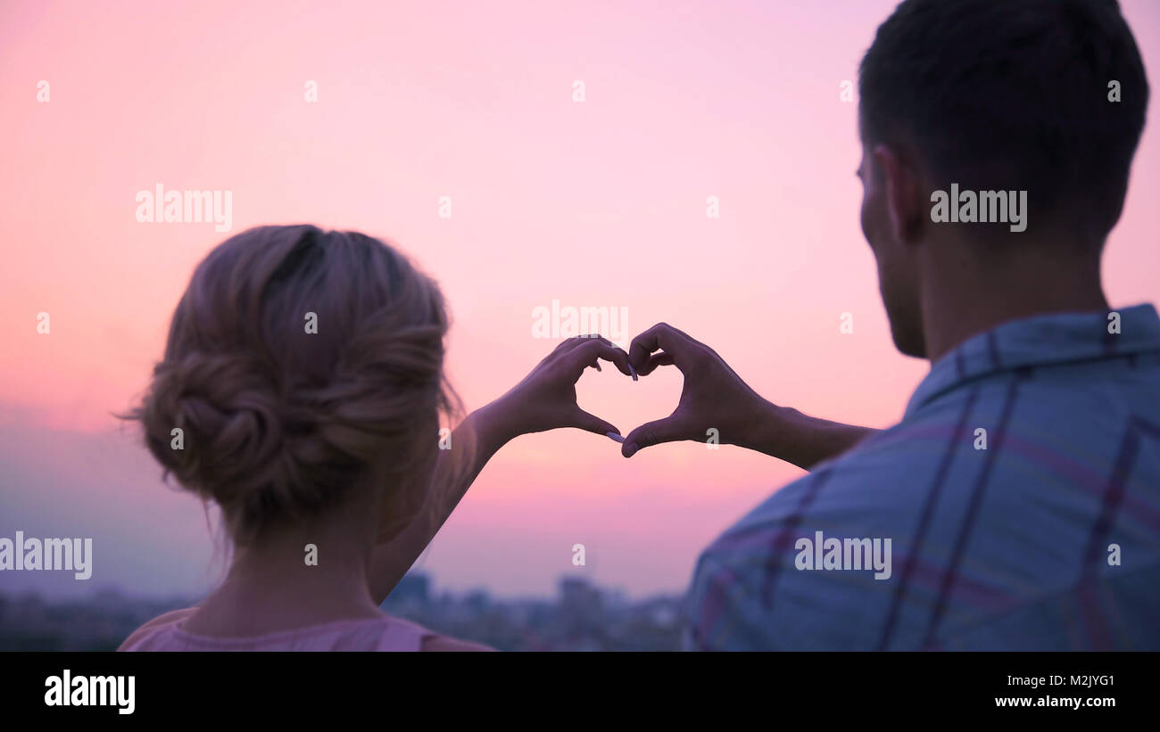 Lovers putting their hands together in shape of heart, demonstrating ...