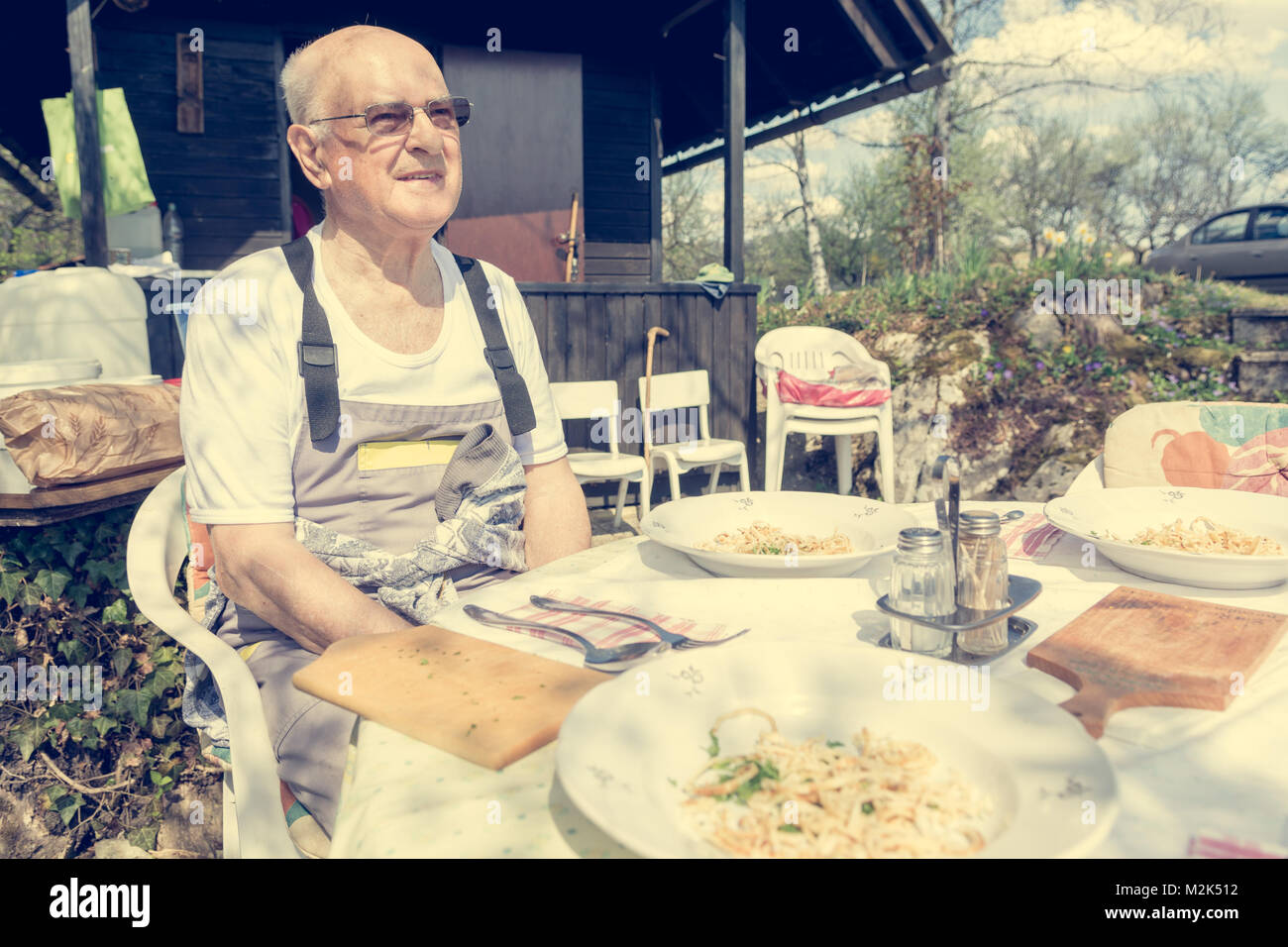Elderly man sitting at lunch table outdoor Stock Photo - Alamy