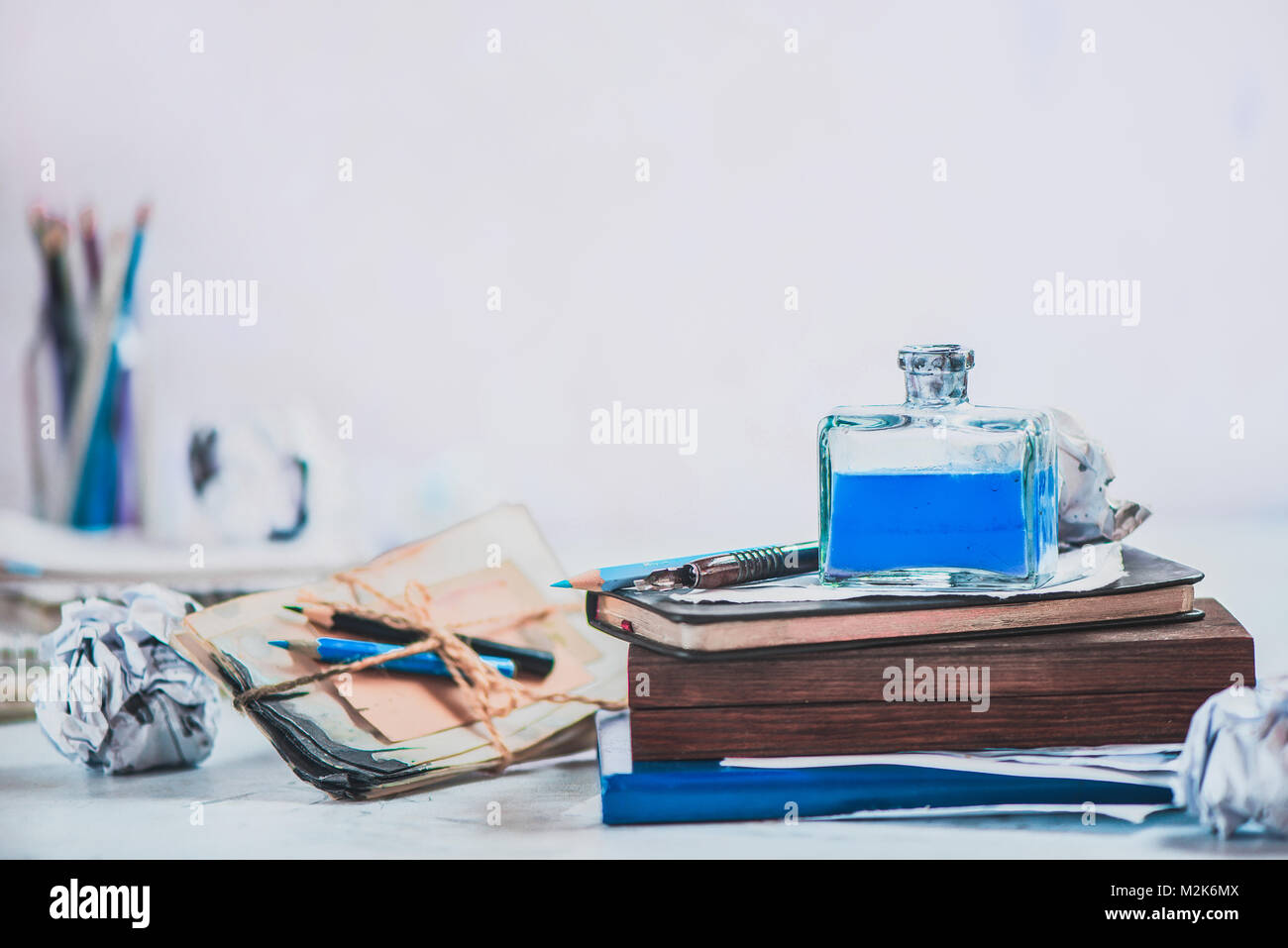 Inkwell on a stack of drafts, pencil boxes and papers.High key still ...