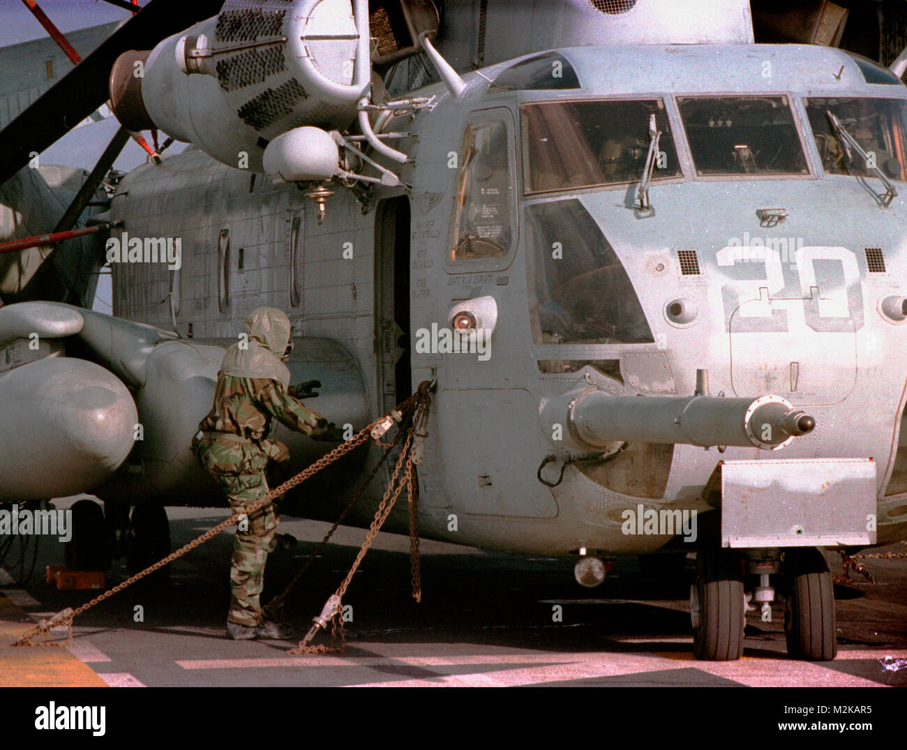 A US Marine decon team member climbs into a helicopter on board the USS ...