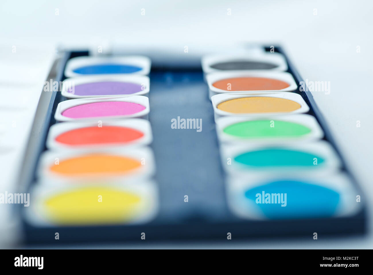 A bright palette of watercolor paints, high key lighting and shallow ...