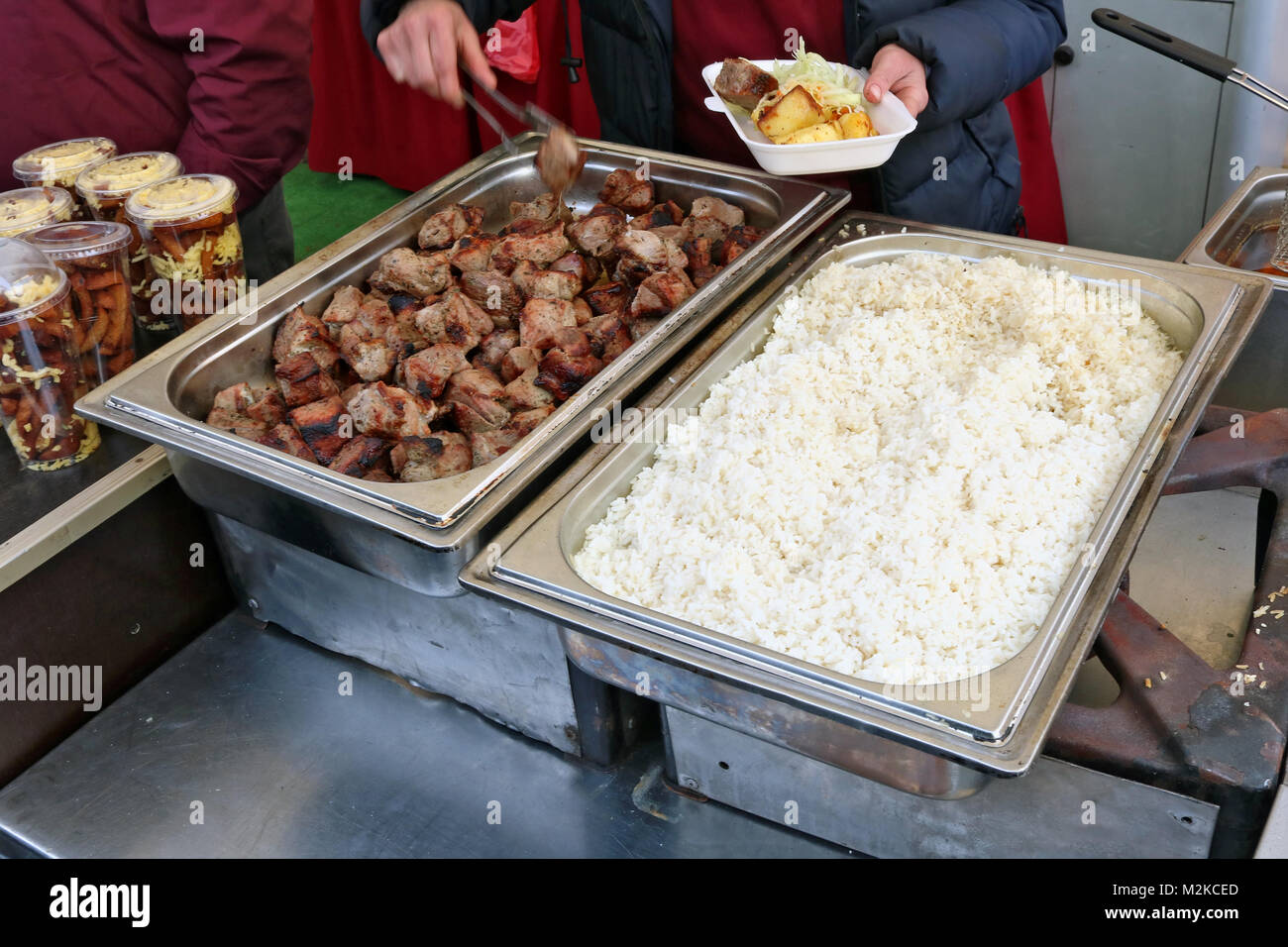 With rapid movements, the street food merchant puts pieces of fried ...