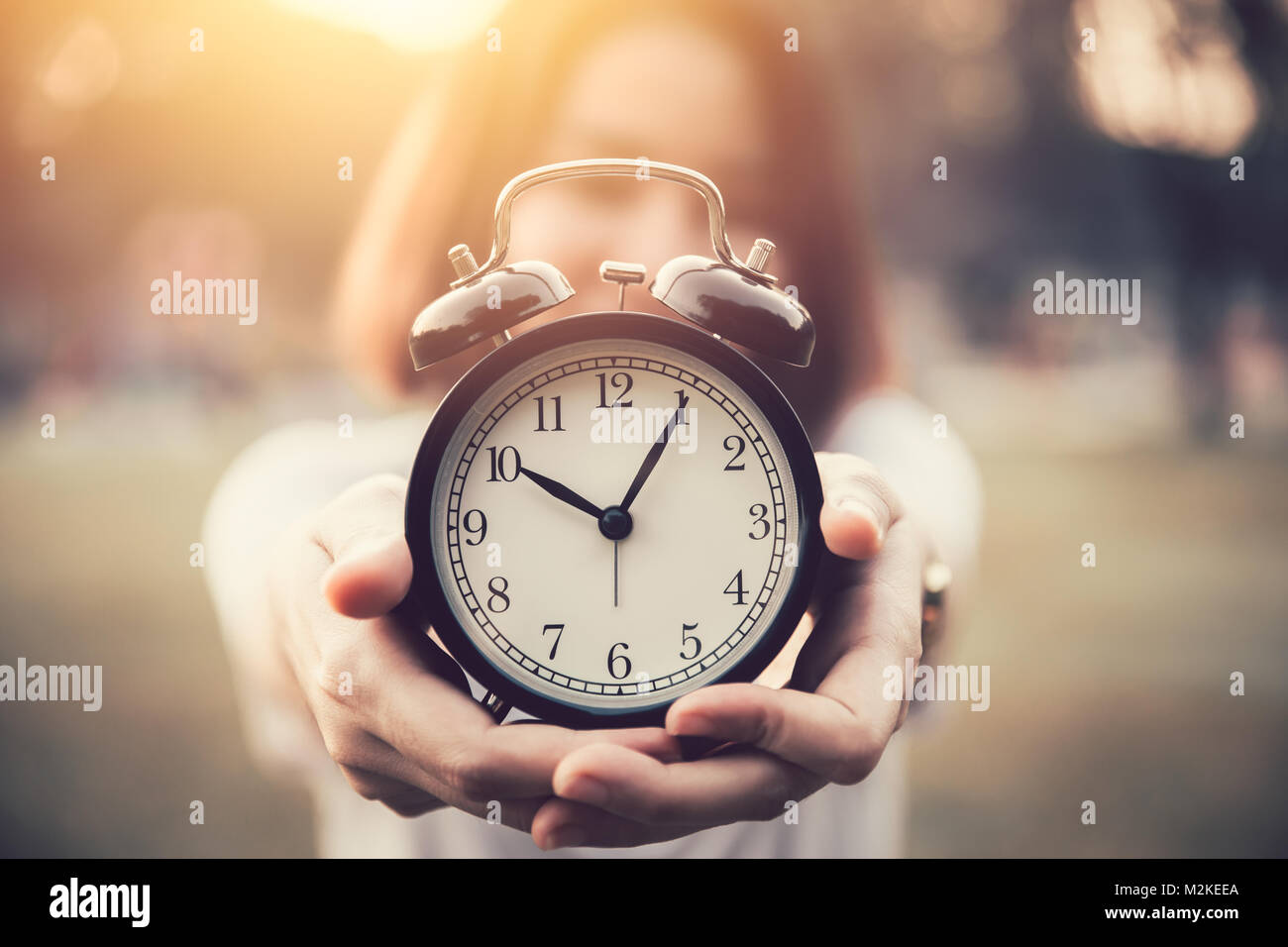 women hold vintage clock in her hand for showing times to do concept ...