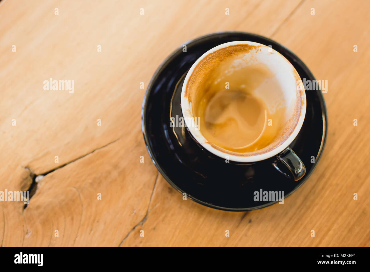 Finished drink of Latte coffee in black cup on wood table background ...