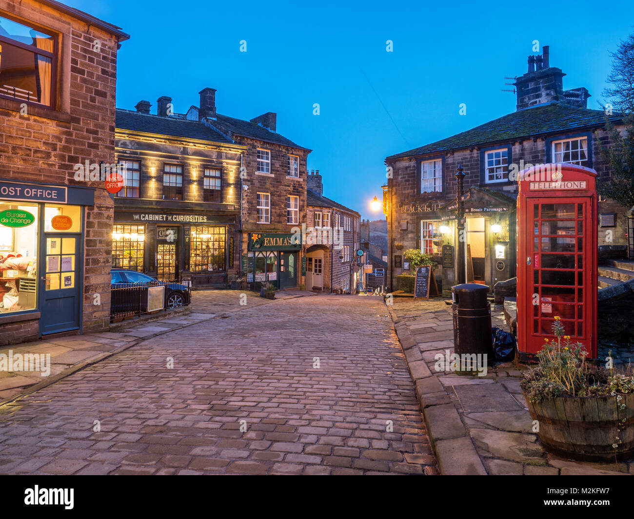 Lights coming on along the cobbled Main Street in Haworth Village at ...
