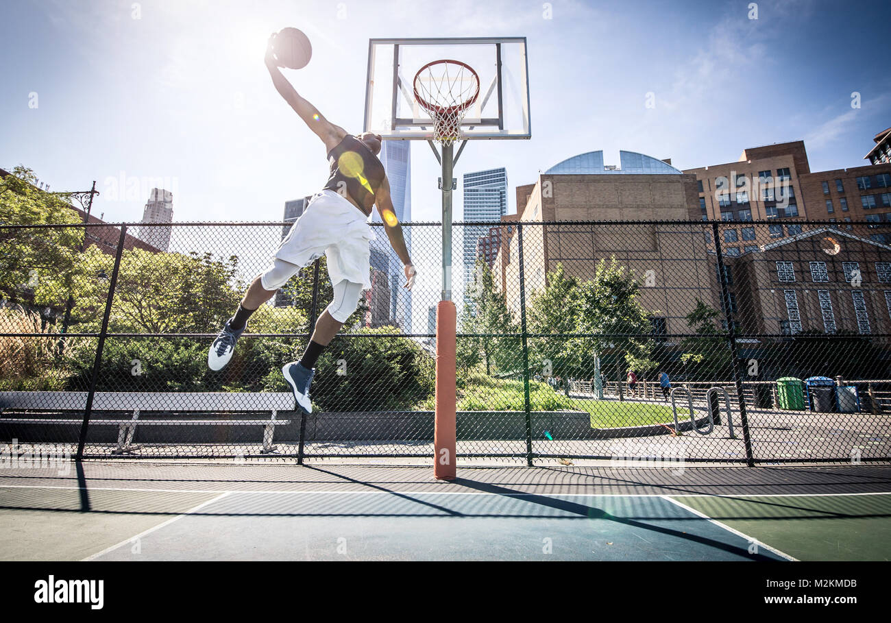 Basketball player making huge slam dunk Stock Photo - Alamy