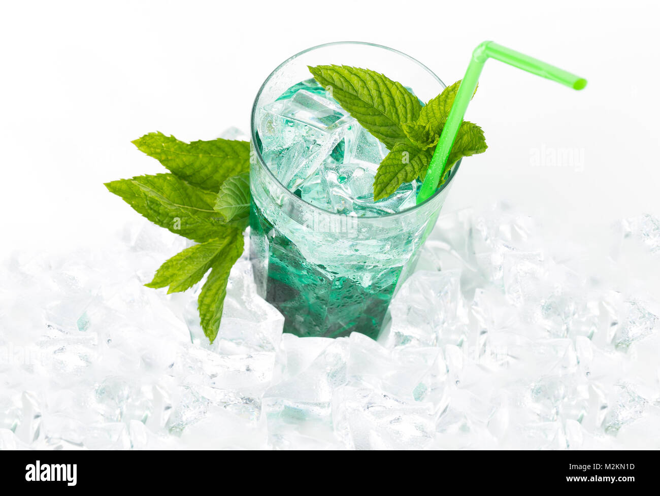 Iced green peppermint syrup with tonic water and ice cubes. Isolated on ...