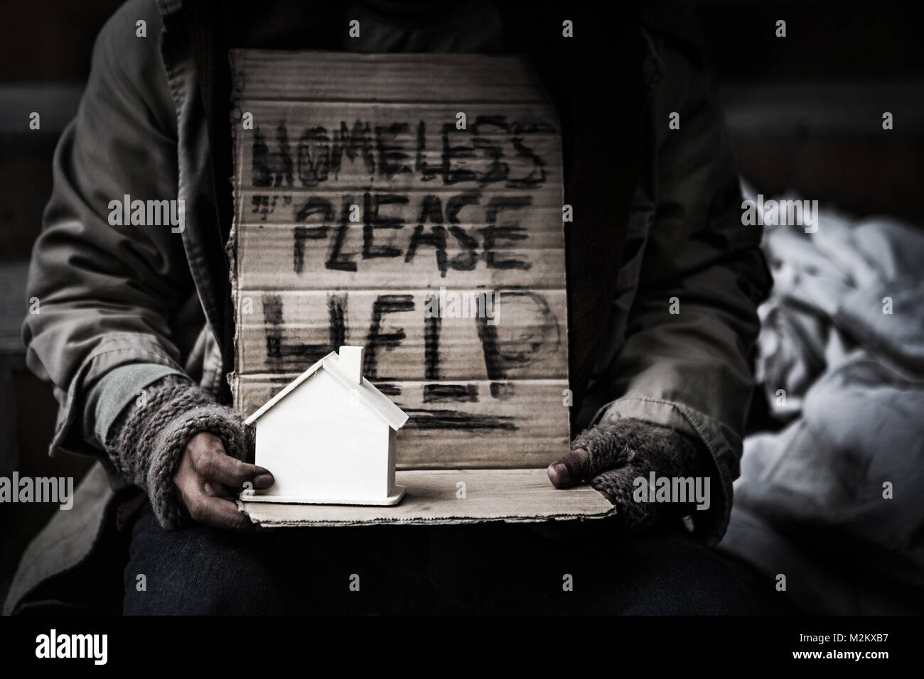 Homeless people need help and beg for home by using house model as ...