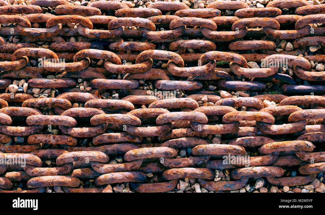 lines of rusted large metal chain on a stony beack Stock Photo - Alamy