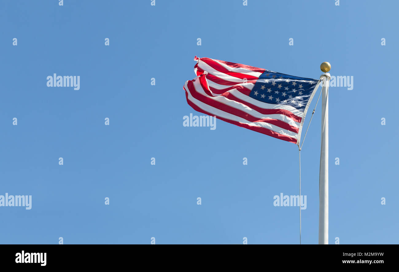 The United States flag on blue sky background, turned to the left Stock ...