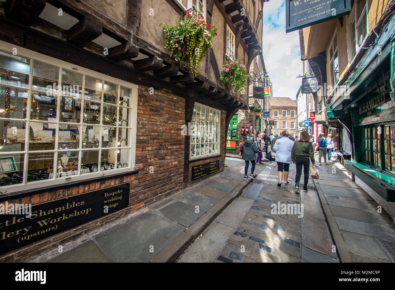 Tourists walk along the historic street of Shambles that features ...