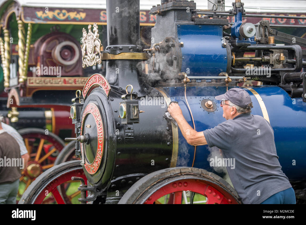 Mature male uses rag to polish steam engine tractor, Masham, North ...