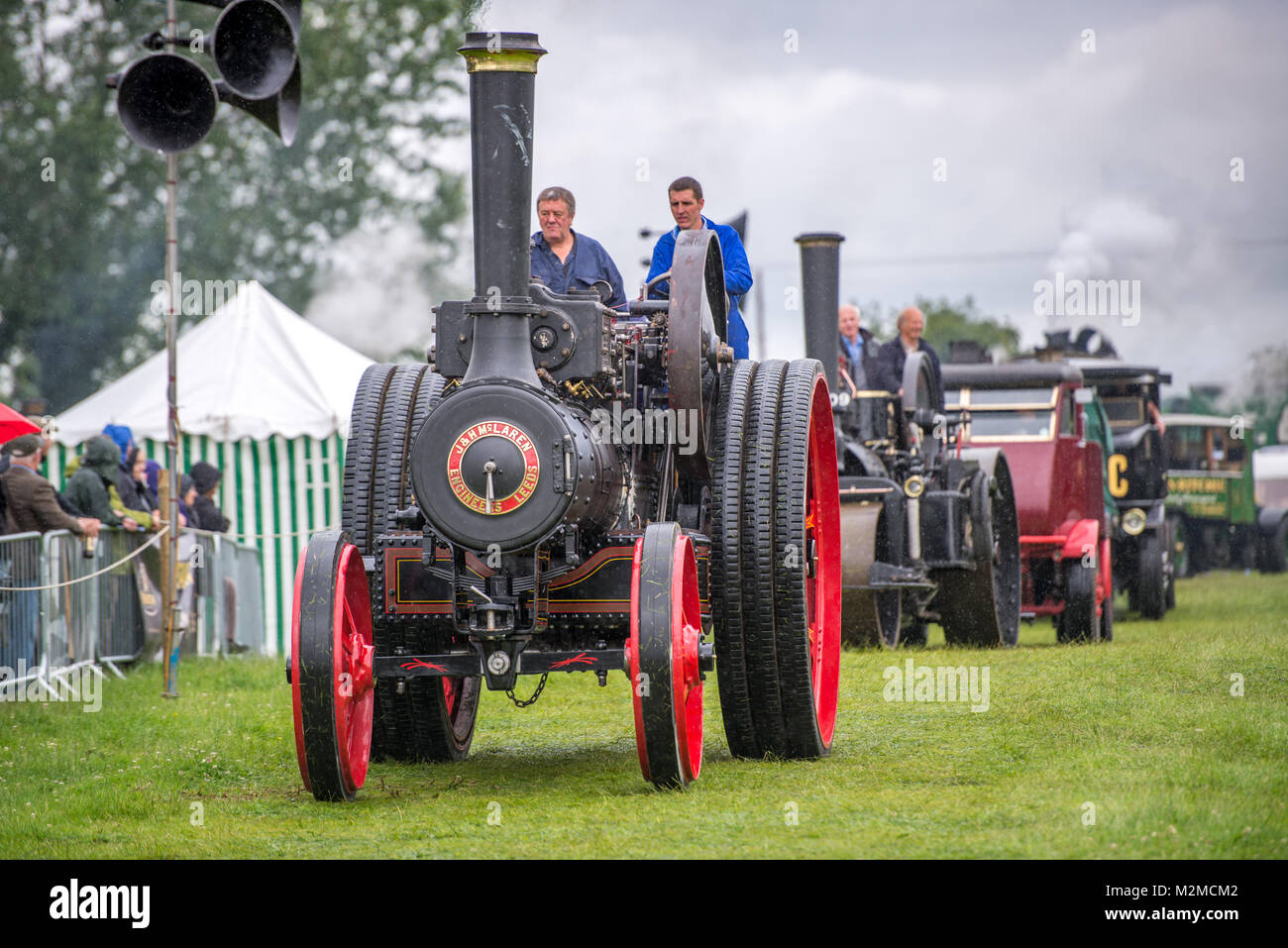 Two mature males drive a vintage steam engine tractor in parade, Masham ...