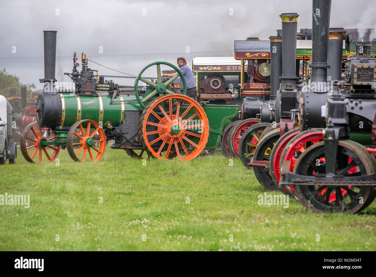 Adult male drives vintage tractor steam engine out of line of other ...
