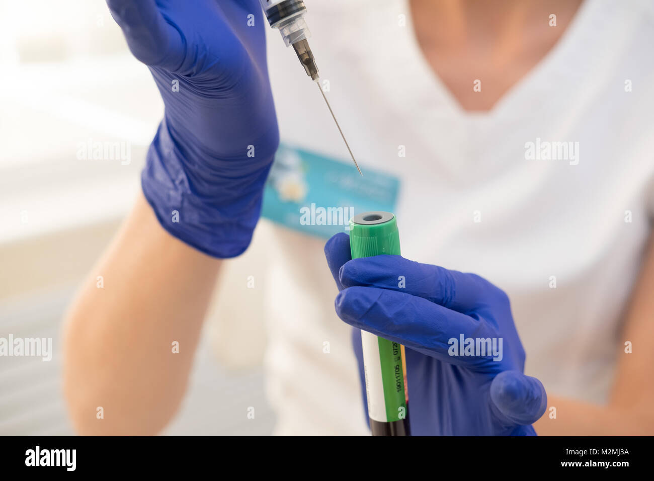 Syringe for medical injection in hands with blue gloves. Nurse or ...