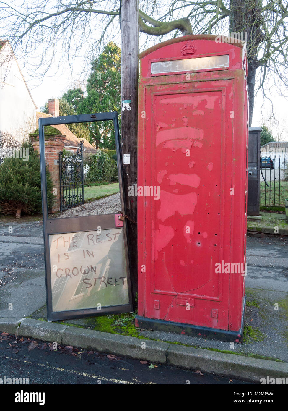 red telephone box with hanging stolen door chained to; essex; england ...