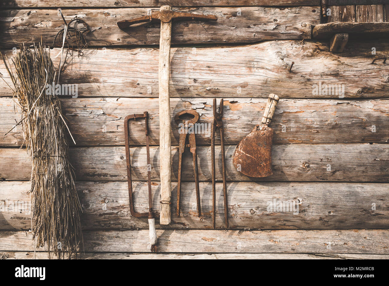Collection of vintage rusty tools displayed on a old wooden background ...