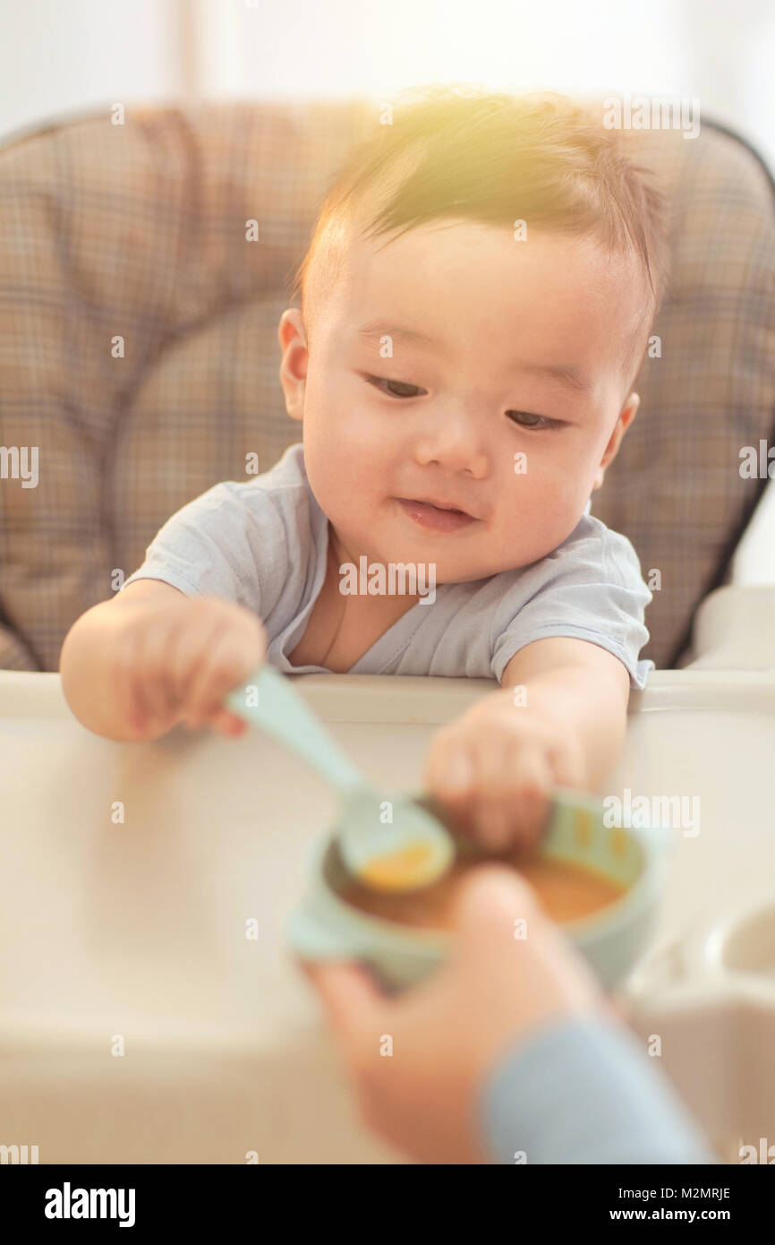 The lovely baby boy is eating Stock Photo - Alamy