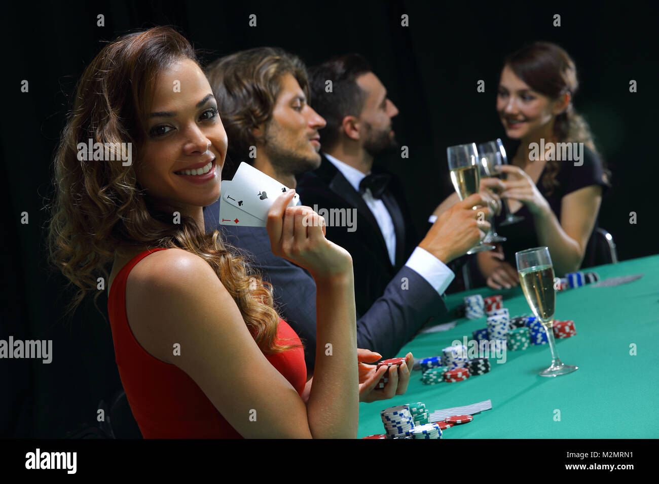 young brunette woman playing poker on black background Stock Photo - Alamy