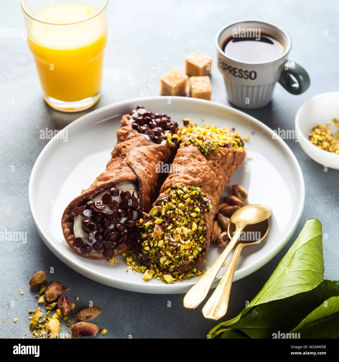 Cannoli with ricotta, chocolate and pistachios. Italian pastries of the ...