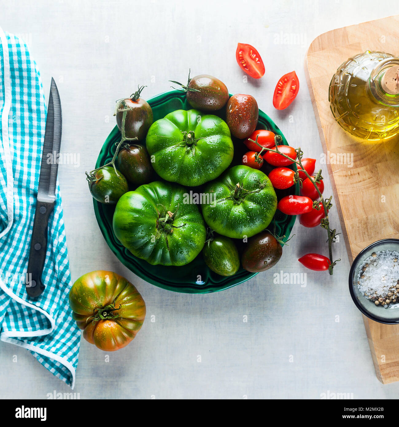 different kinds, types and color of tomatoes on a white stone table ...