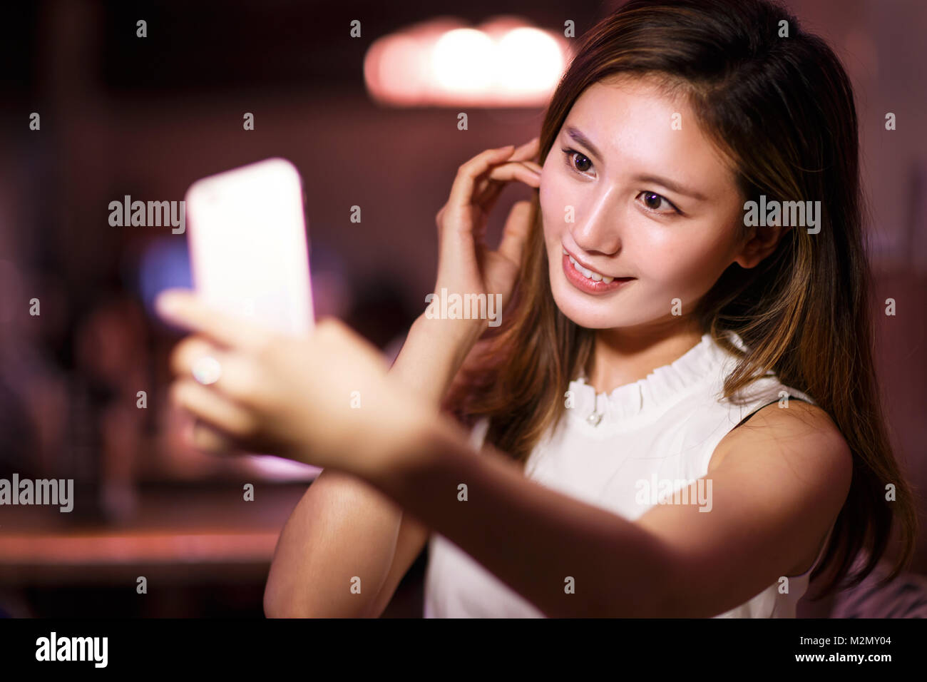 Young women use mobile phone self timer Stock Photo - Alamy