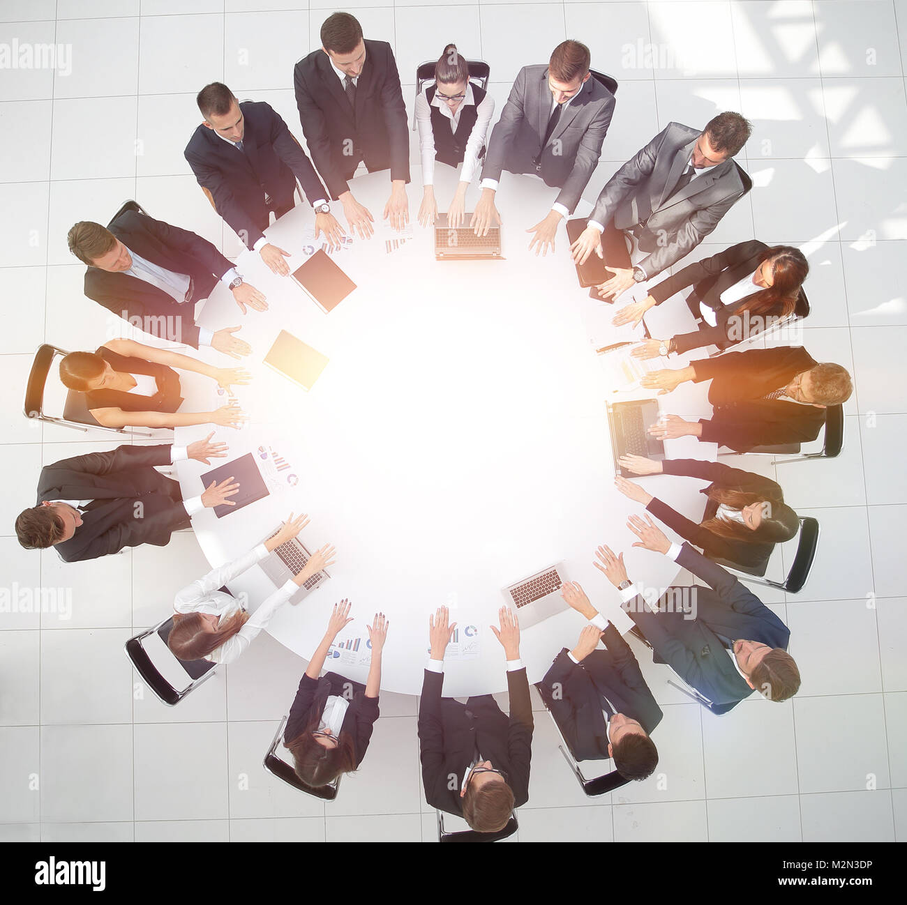 group of business people sitting at the round table, and putting his ...