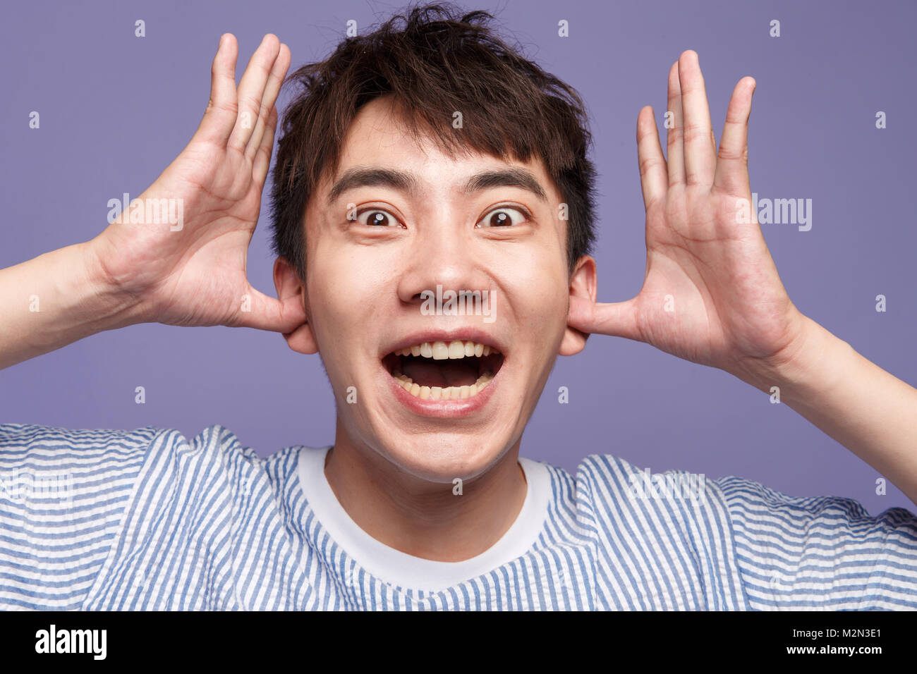 The young man screaming covering her ears Stock Photo - Alamy