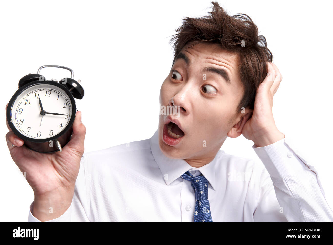 Shocking business young man with an alarm clock Stock Photo - Alamy