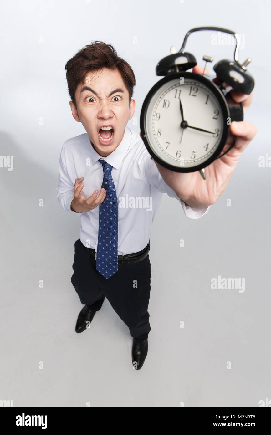 Business young man with an alarm clock Stock Photo - Alamy