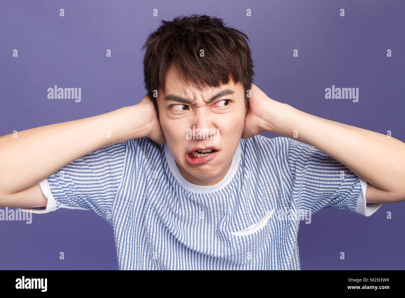 The young man screaming covering her ears Stock Photo - Alamy