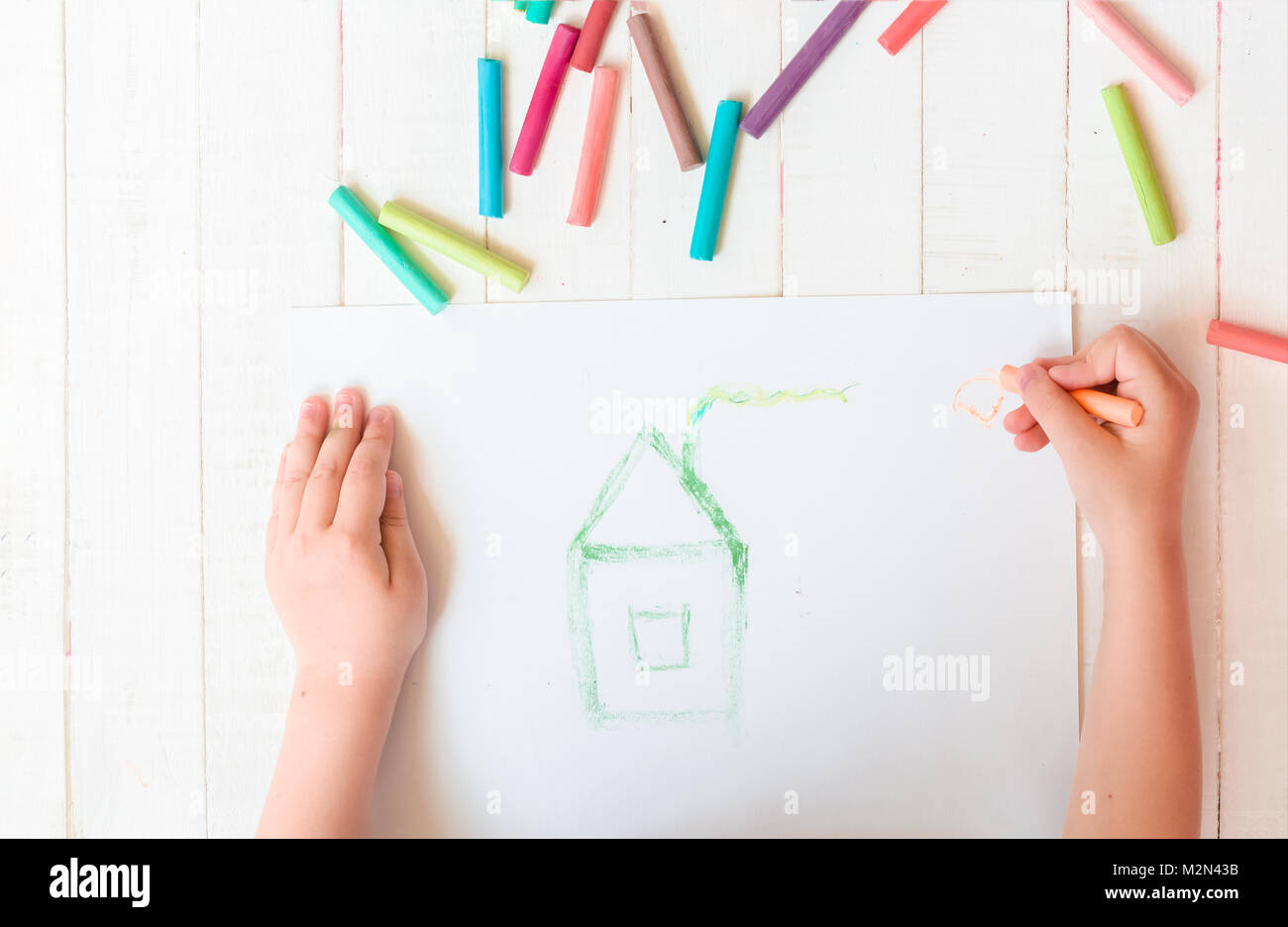 A child draws a house with crayons. House. Multicolored crayons, pastel ...