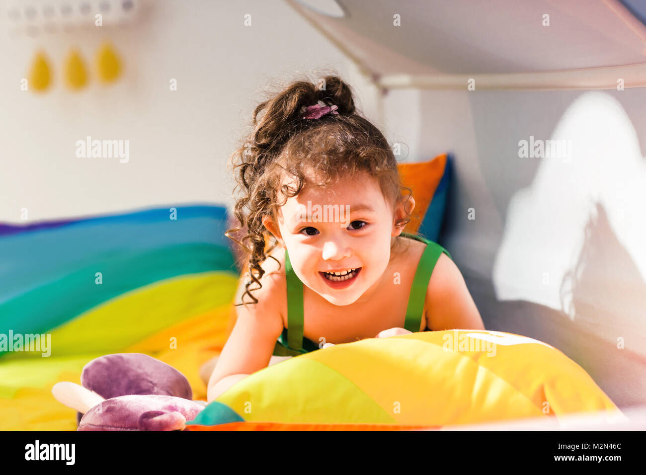 Cute little girl playing on the bed Stock Photo - Alamy