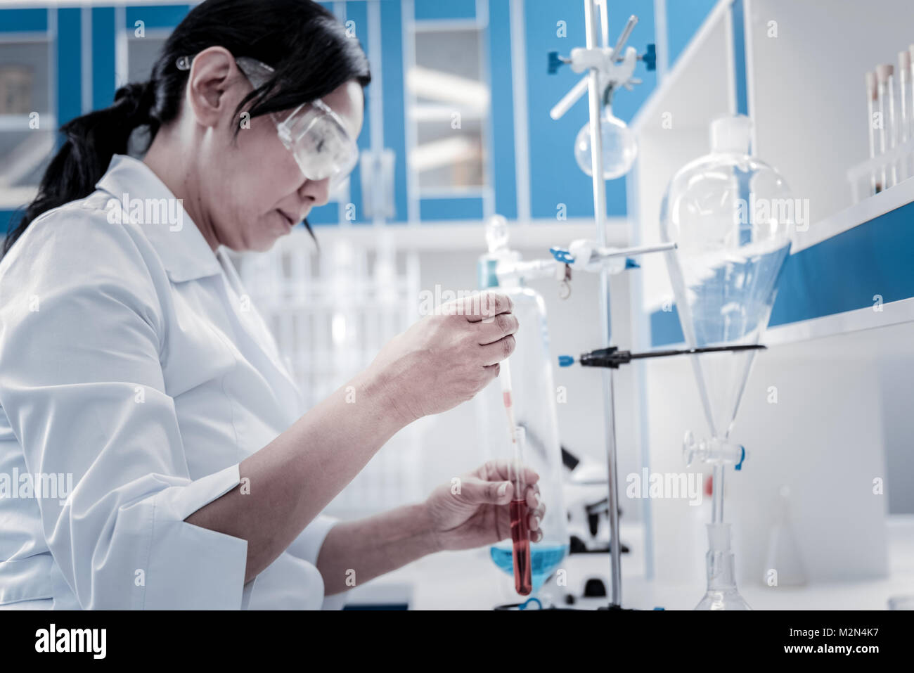 Mature scientist pouring chemical liquid into test tube Stock Photo - Alamy