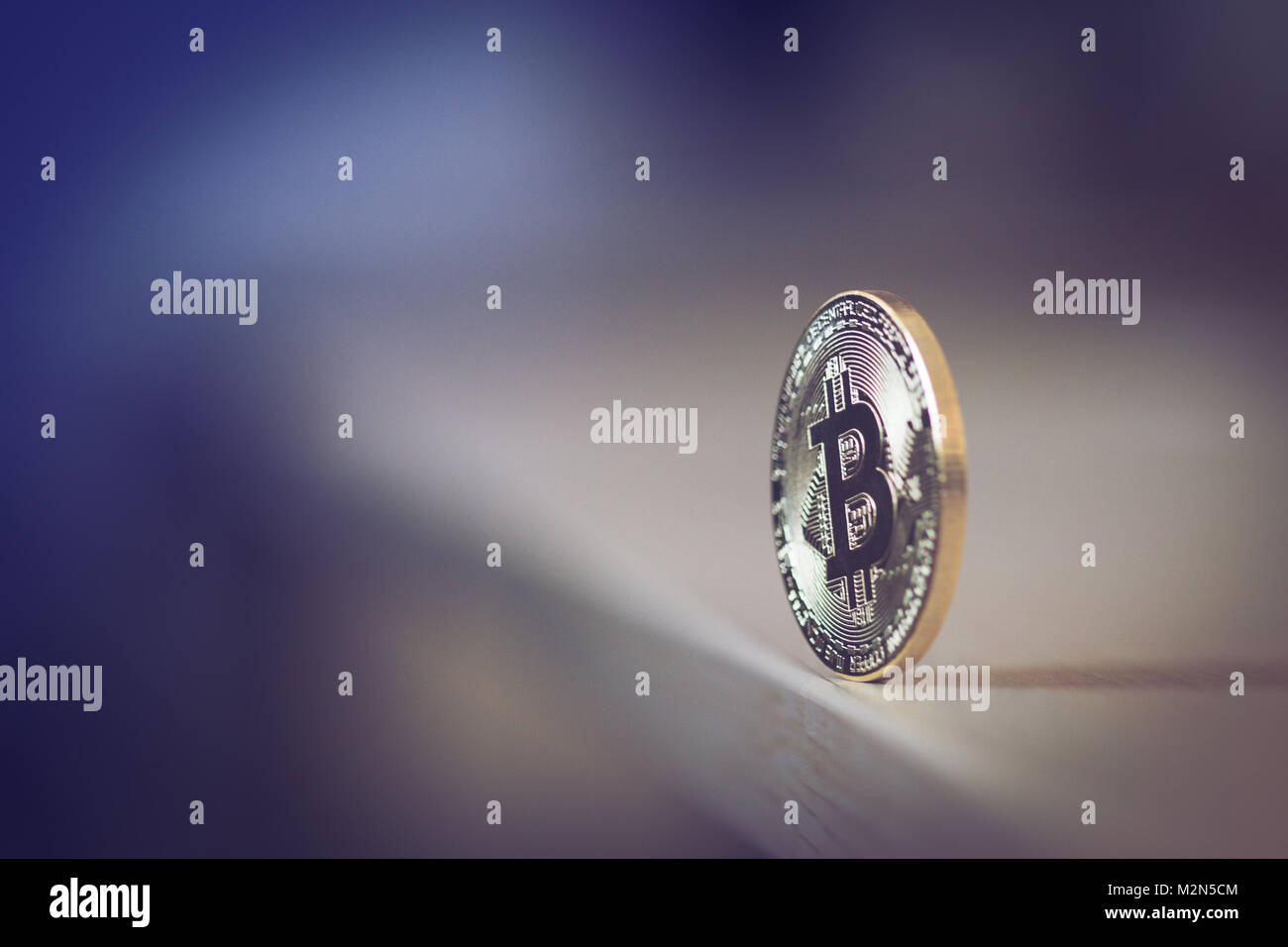 side view with selective focus of one bitcoin standing in equilibrium ...