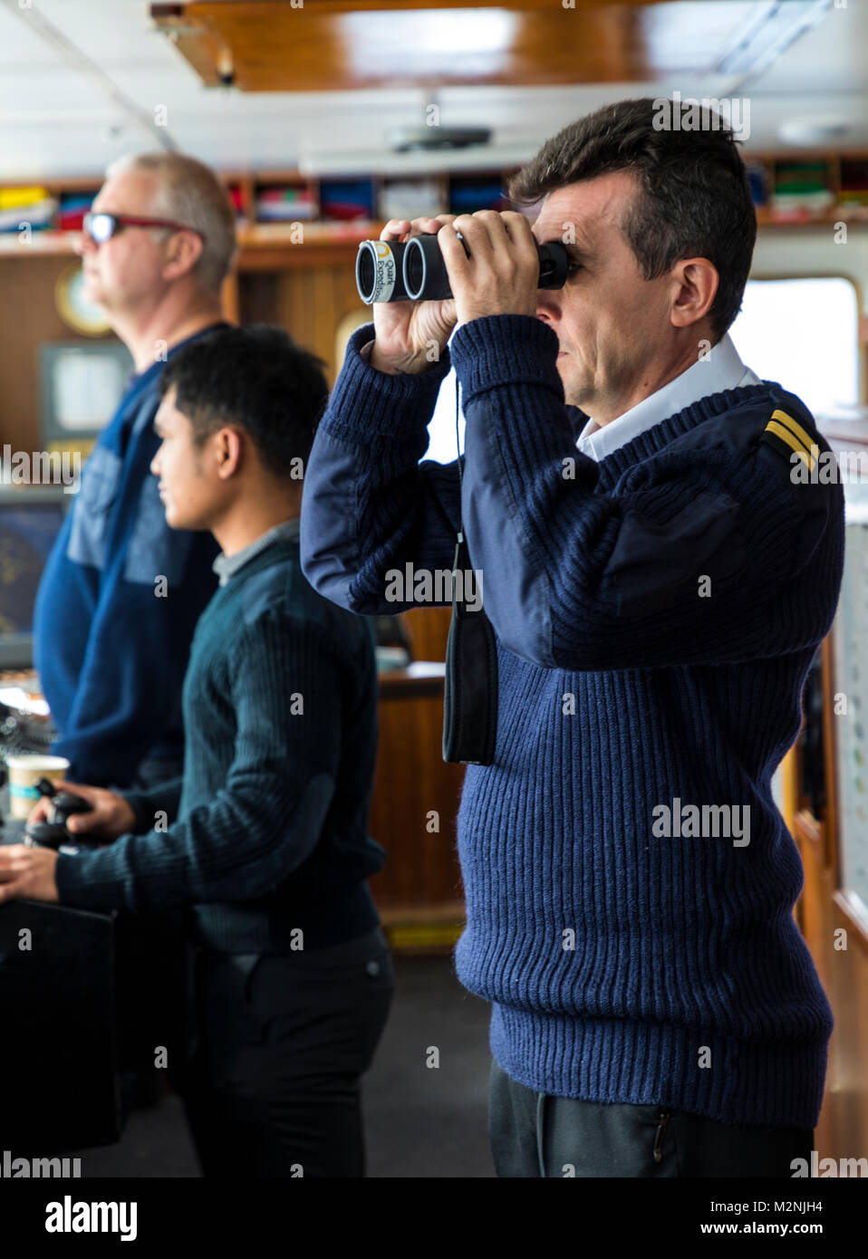 Ship's crew on bridge sailing passenger ship Ocean Adventurer; carries ...