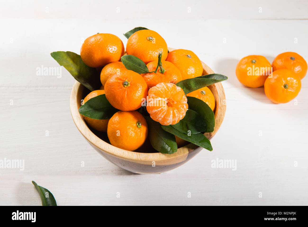 Delicious and beautiful mini Tangerines with leaves in the wooden bowl ...