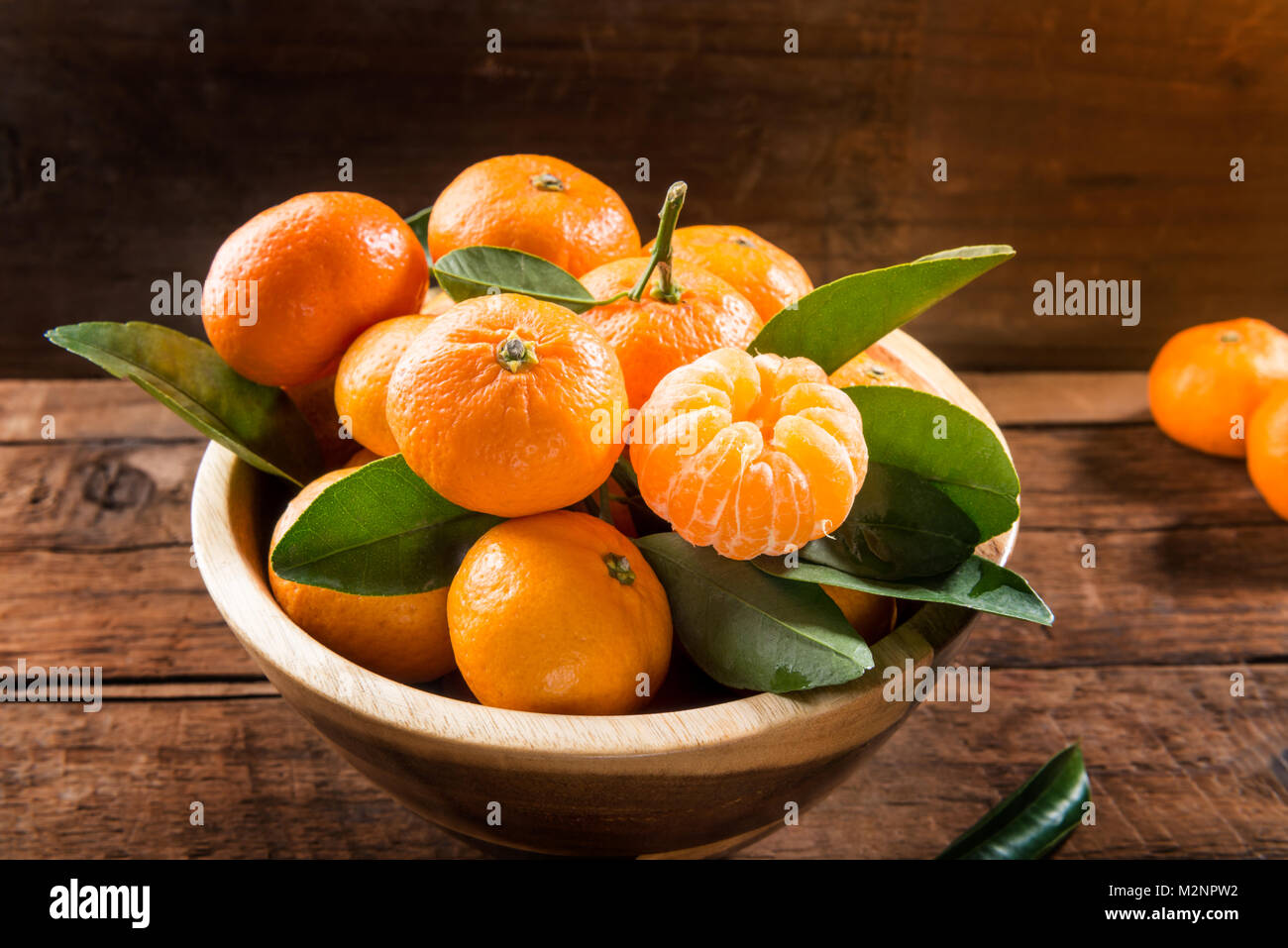 Delicious and beautiful mini Tangerines with leaves in the wooden bowl ...