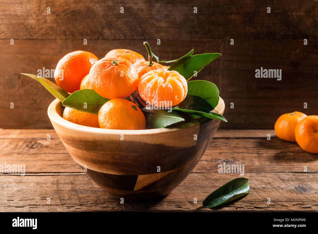 Delicious and beautiful mini Tangerines with leaves in the wooden bowl ...