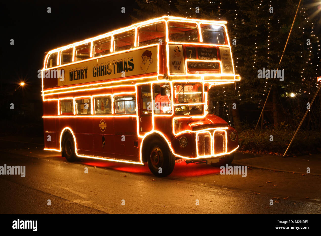 A red christmas bus on the road Stock Photo - Alamy