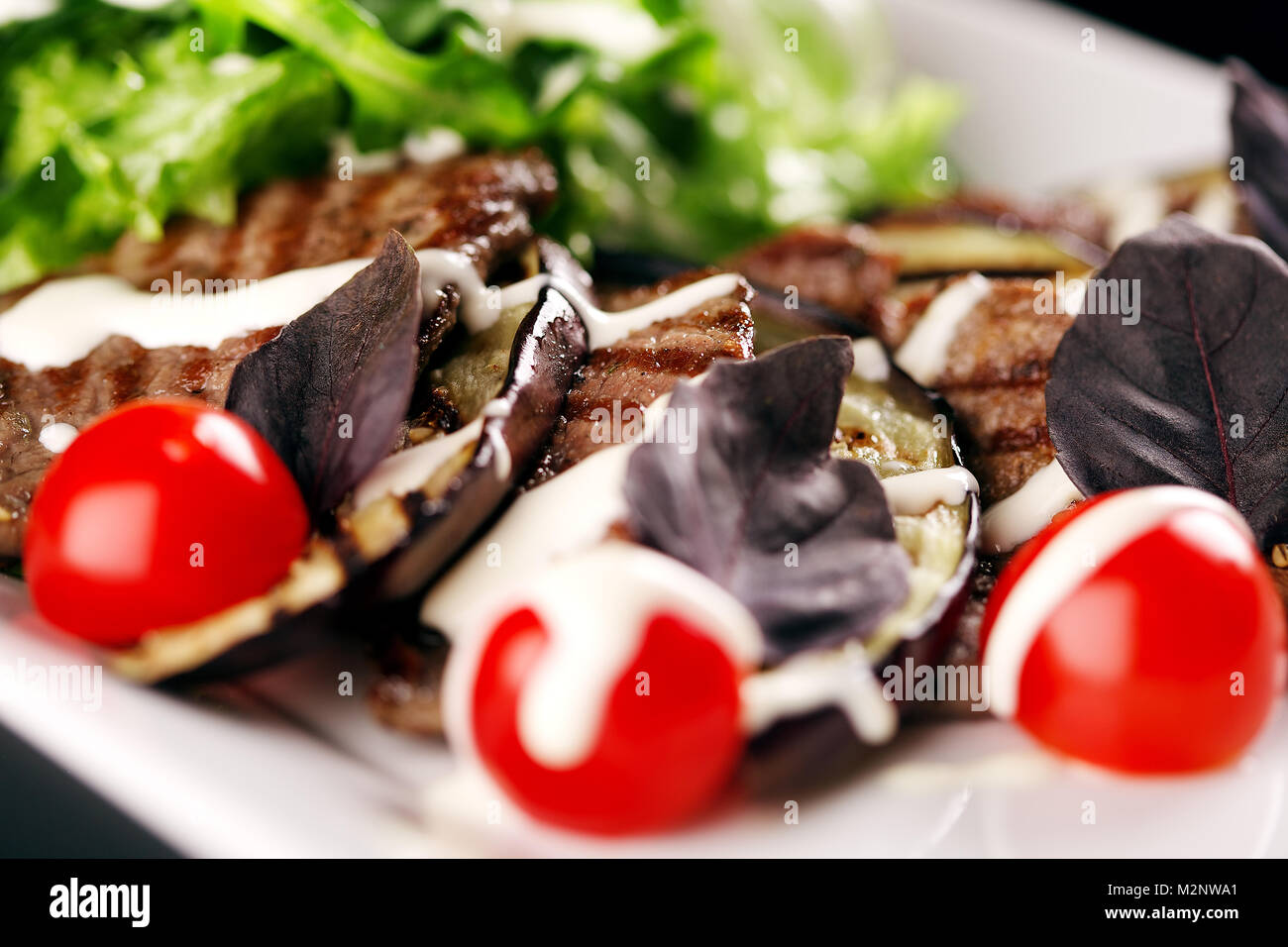 juicy meat decoration with greens and cherry tomatoes Stock Photo - Alamy