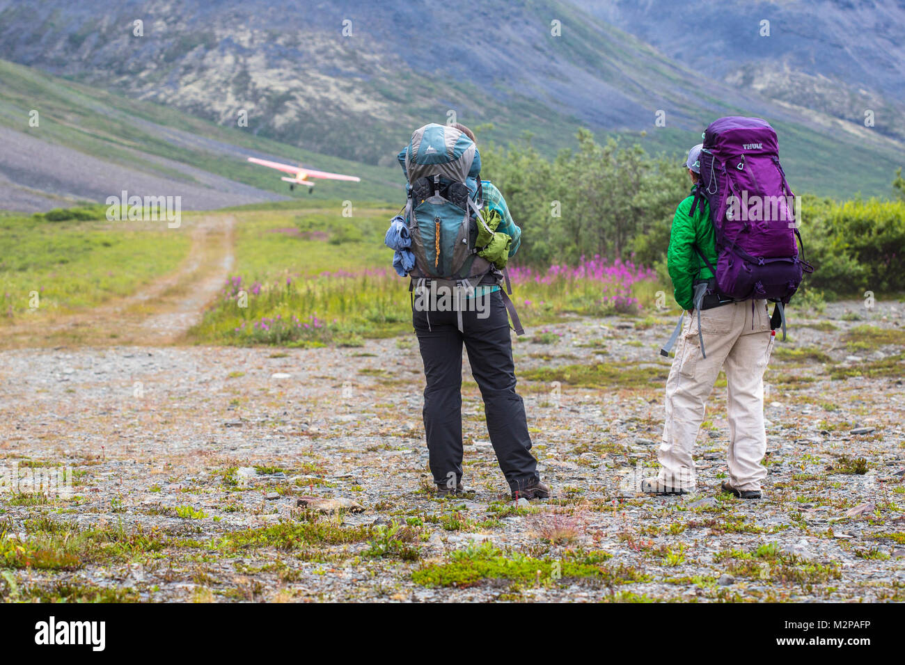 Backpackers Watching their Flight Leave Stock Photo - Alamy