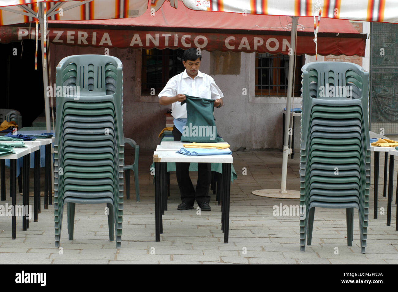 Venice, Italy. Waiter prepares the tables of a pizzeria Stock Photo - Alamy