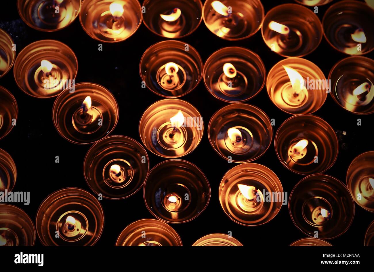 candles lit with the warm flame during the holy mass ceremony with ...