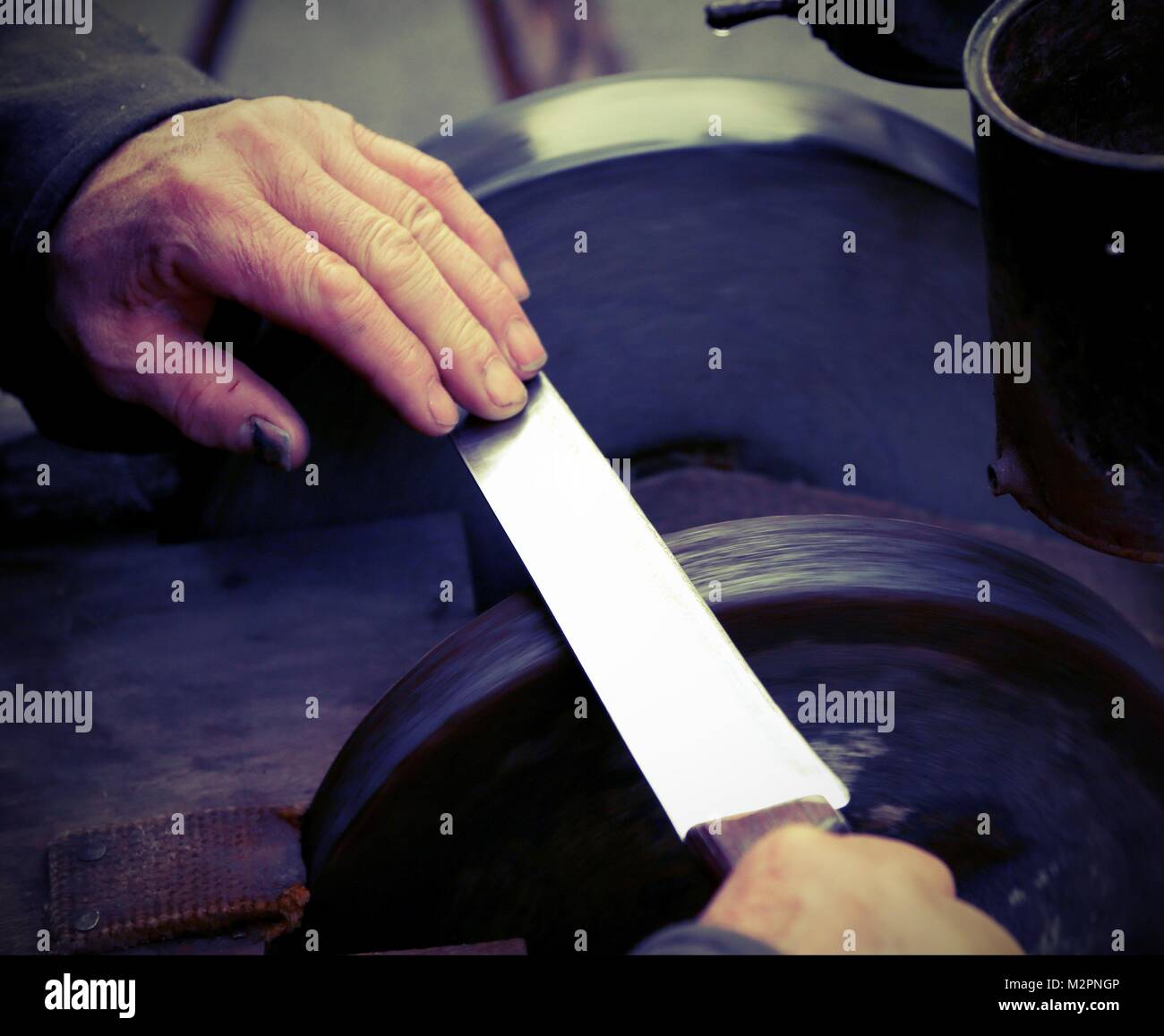 Elder grinder with hands sharpen a blade with vintage effect Stock ...
